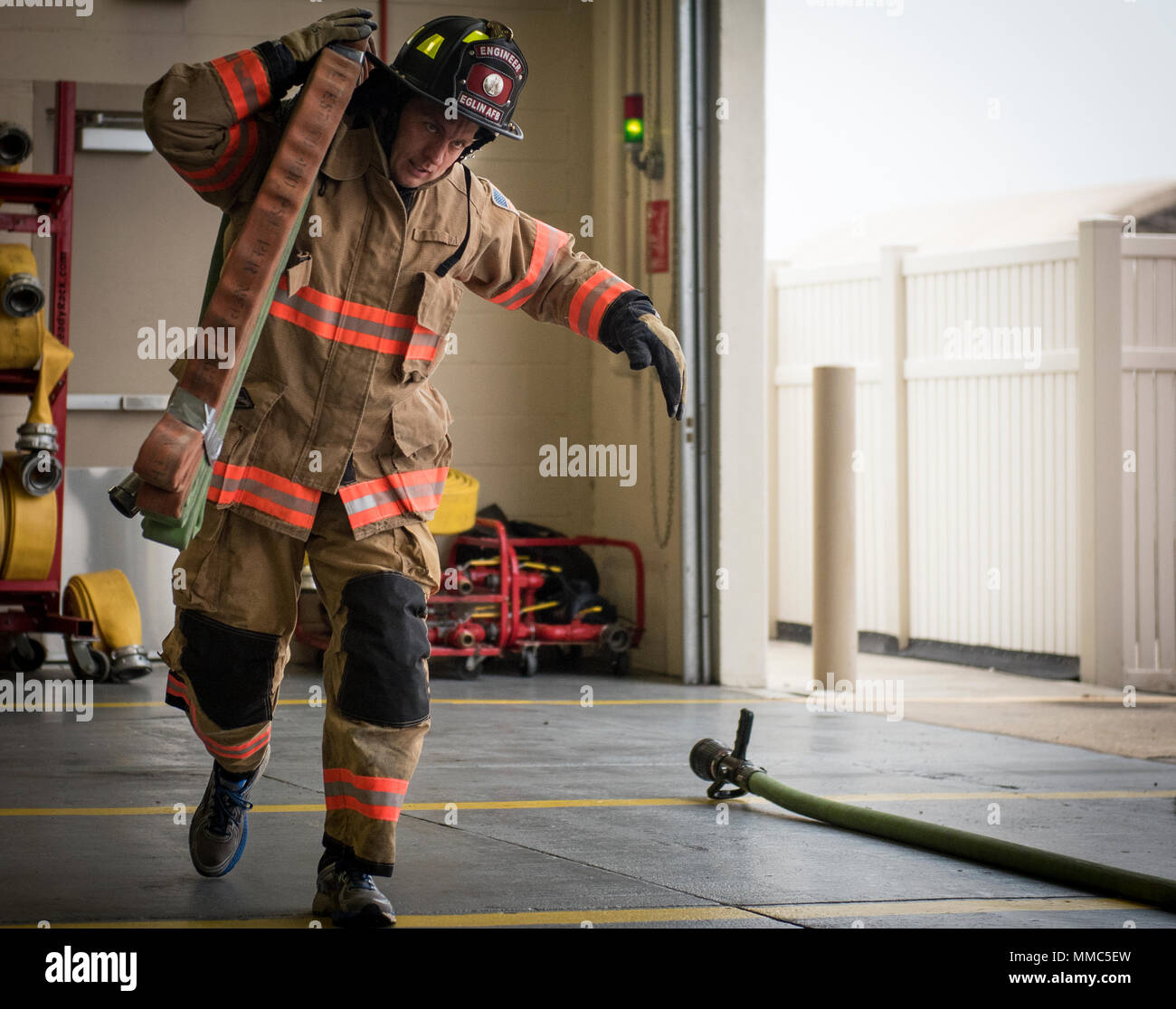A base leadership competitor carries a fire hose during the eighth ...