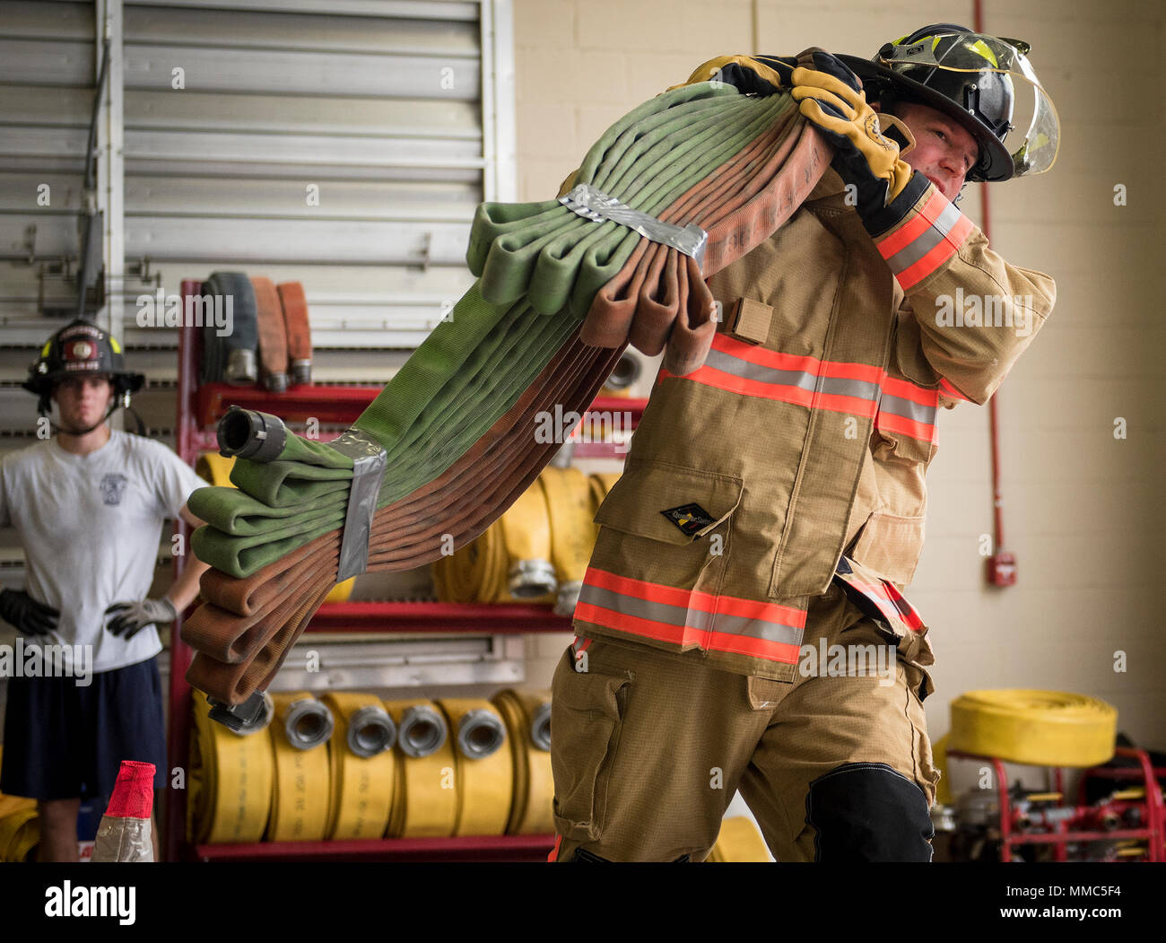 A base leadership competitor carries a fire hose during the eighth ...