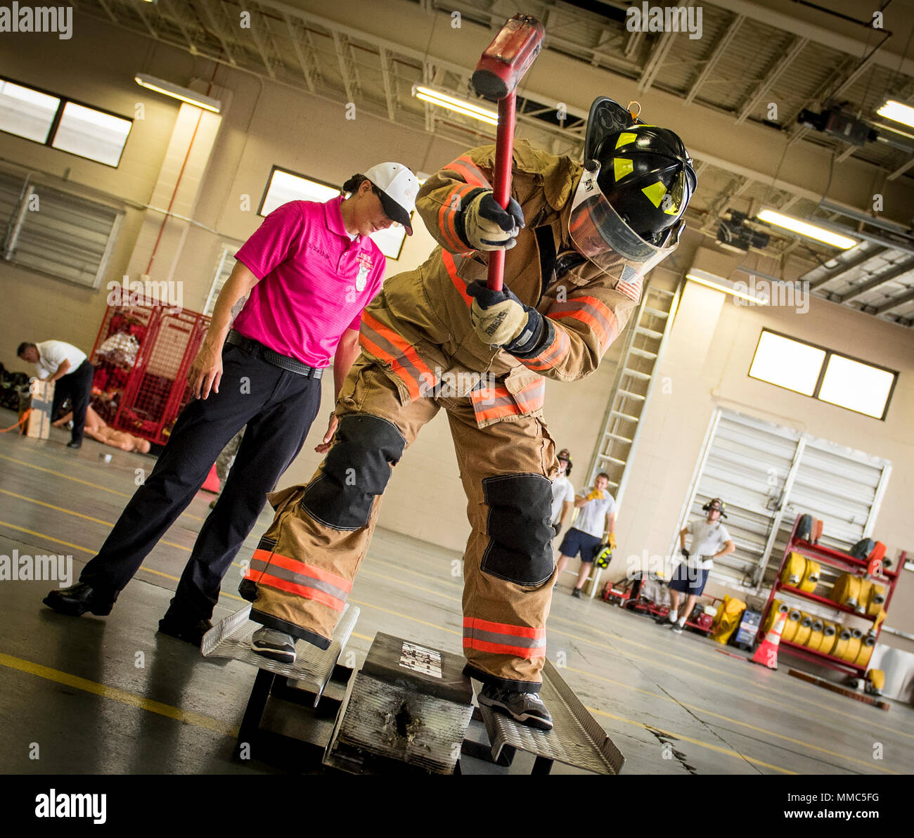 A participant brings a sledgehammer down through the sled during the ...