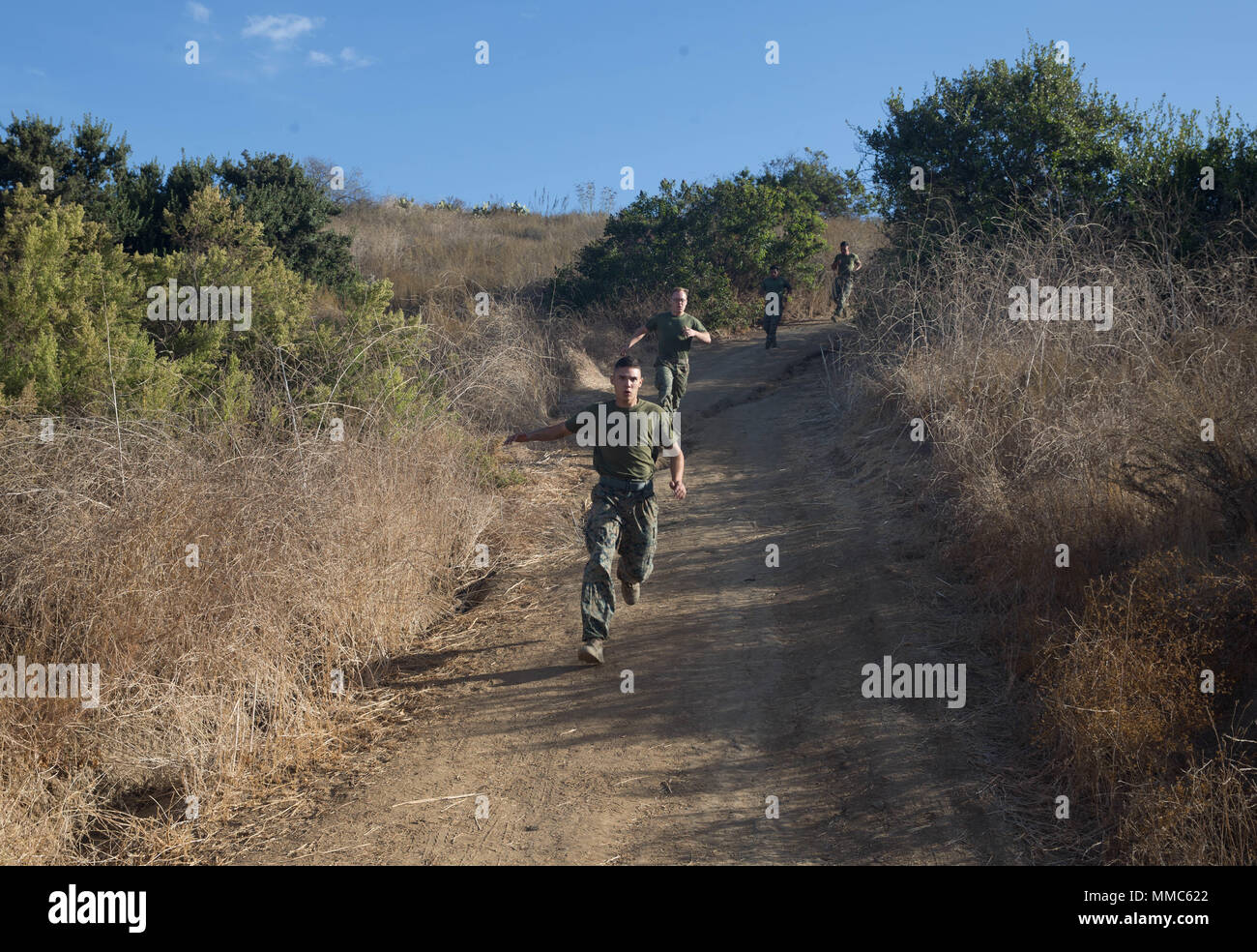 U.S. Marines run down a steep hill during the Outdoor Obstacle Course ...