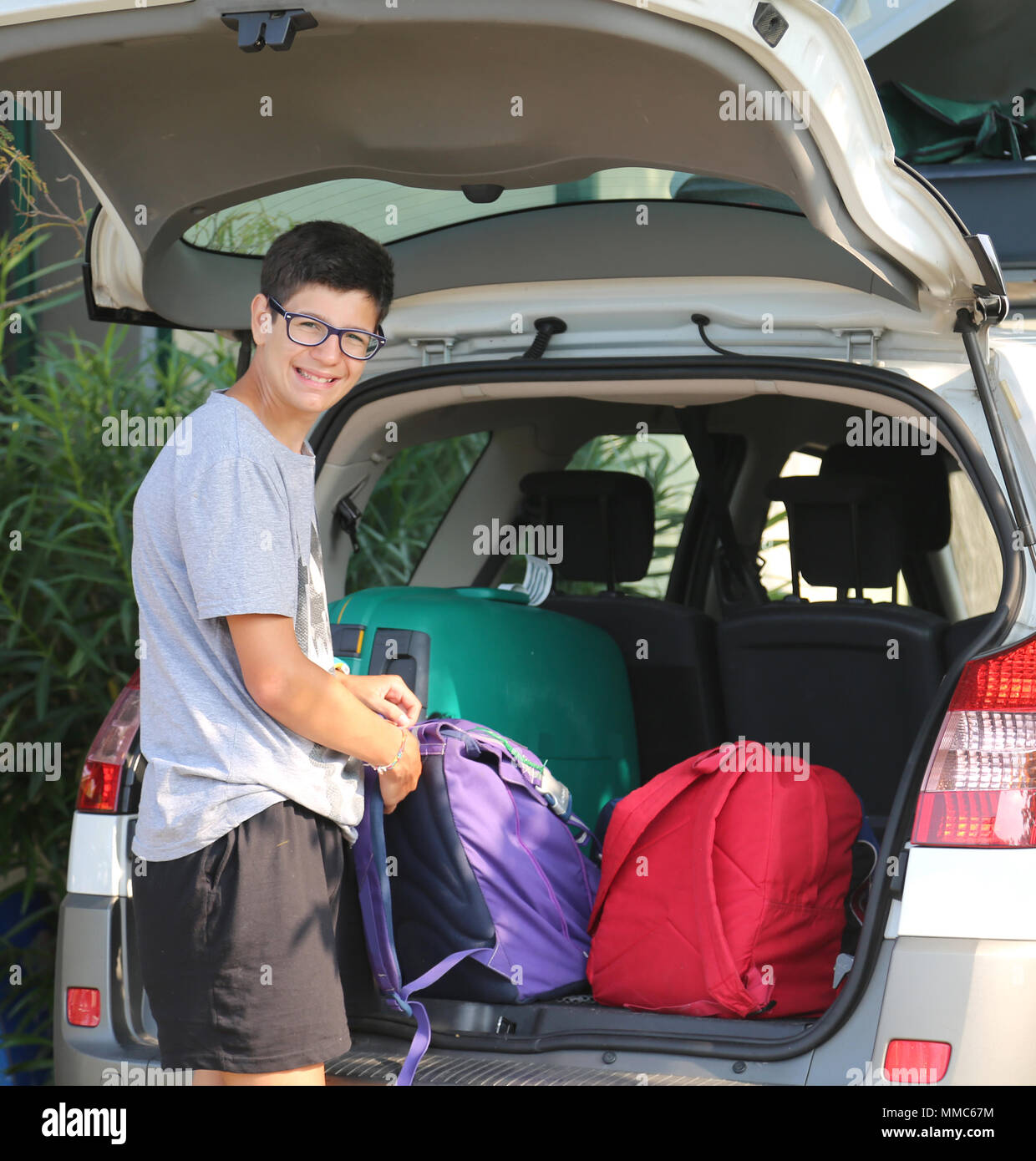 boy loads the baggage in the car before leaving for the trip Stock ...