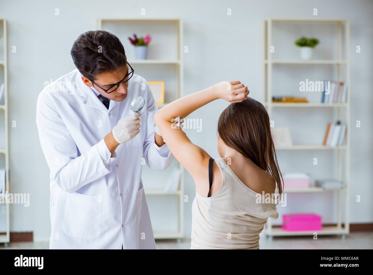 Doctor examining the skin of female patient Stock Photo - Alamy