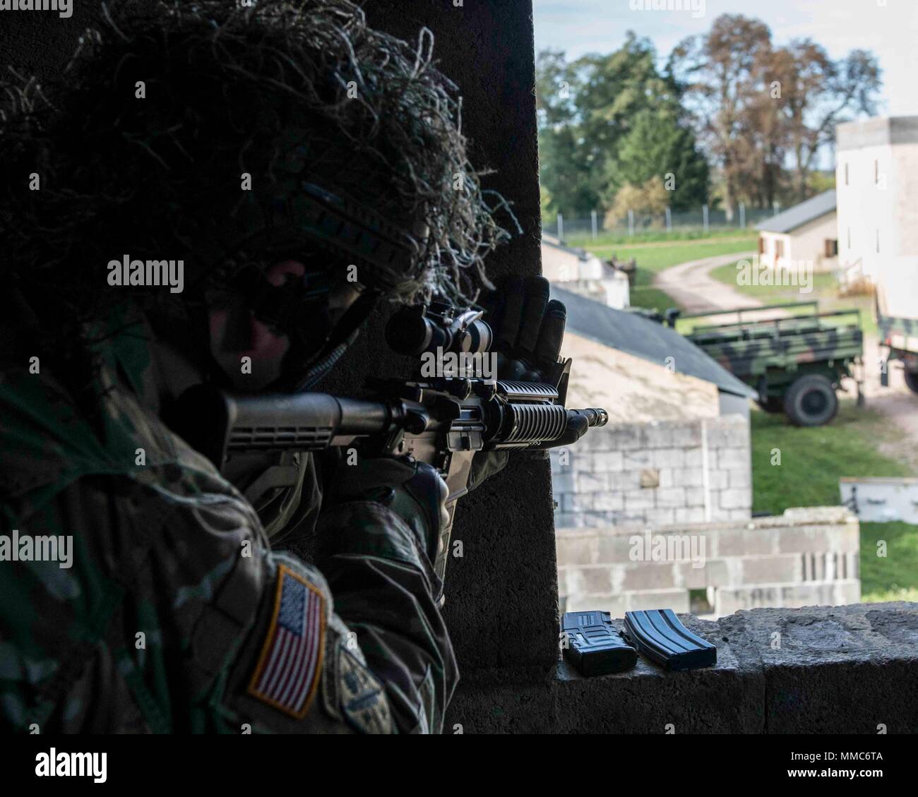 A U.S. Army soldier takes aim at a patrol simulating a combat situation ...
