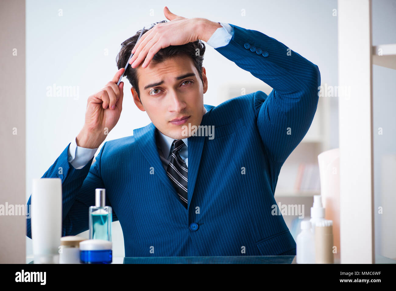 Man is getting dressed up for work in bathroom Stock Photo - Alamy