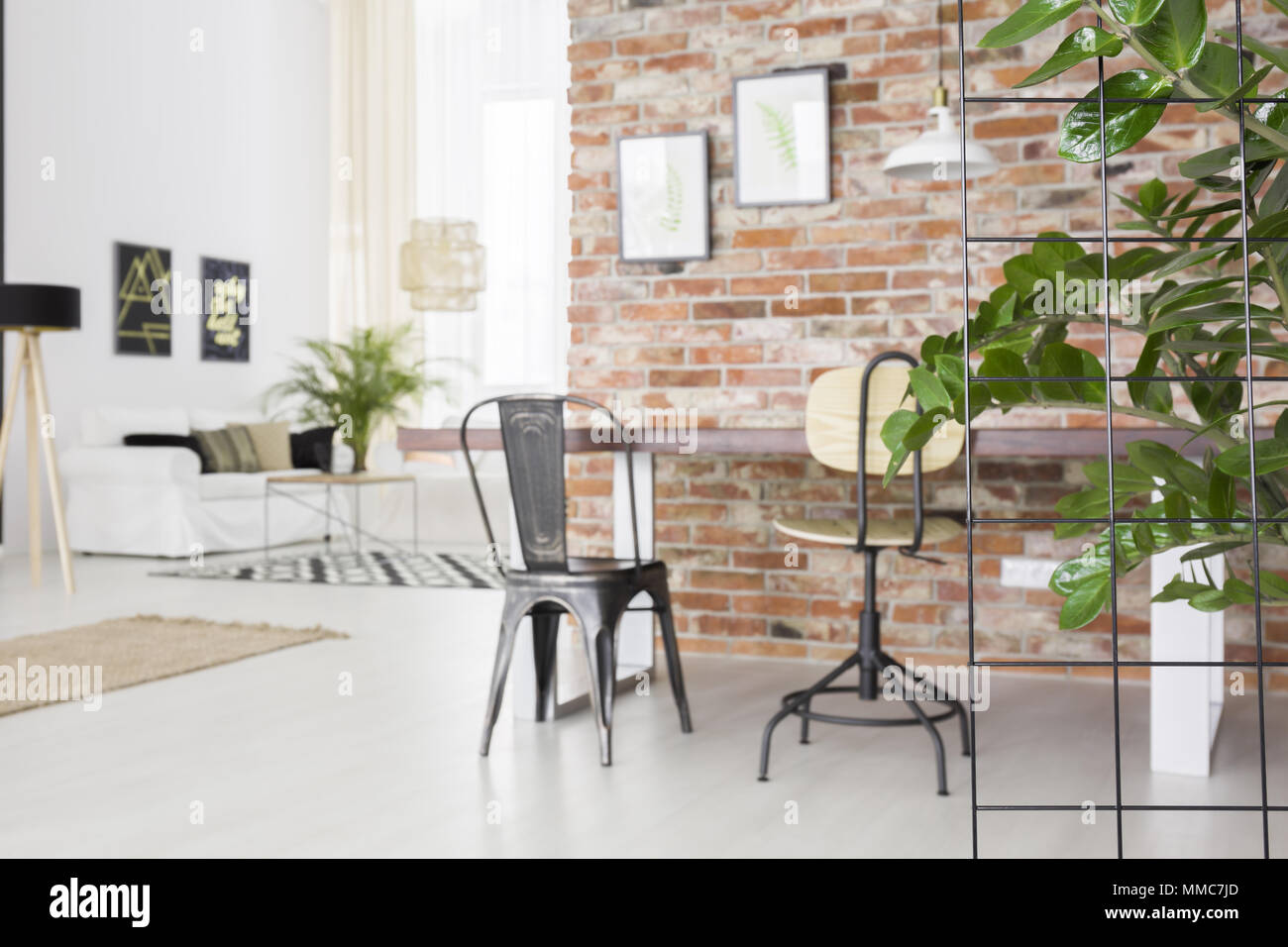 Loft interior with dining table, brick wall and green plant Stock Photo ...