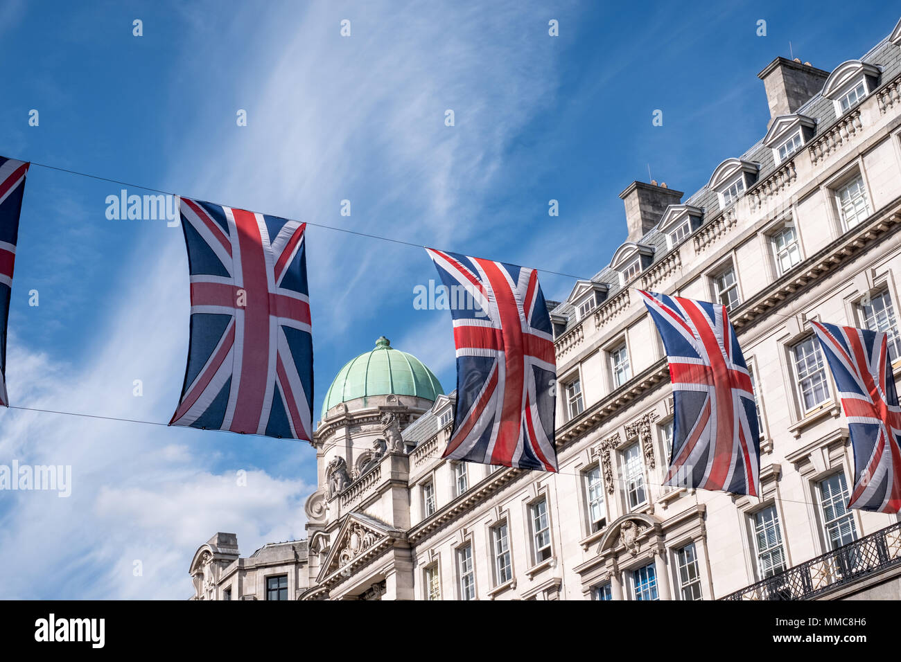 Close up of buildings on Regent Street London with row of British flags ...