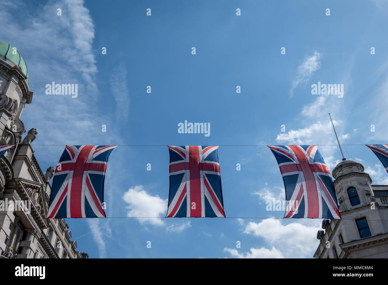 Close up of buildings on Regent Street London with row of British flags ...
