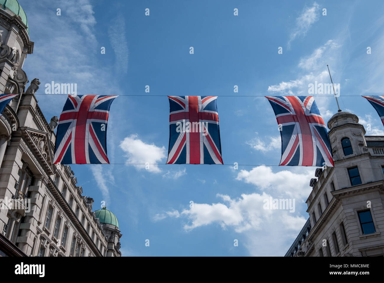 Close up of buildings on Regent Street London with row of British flags ...