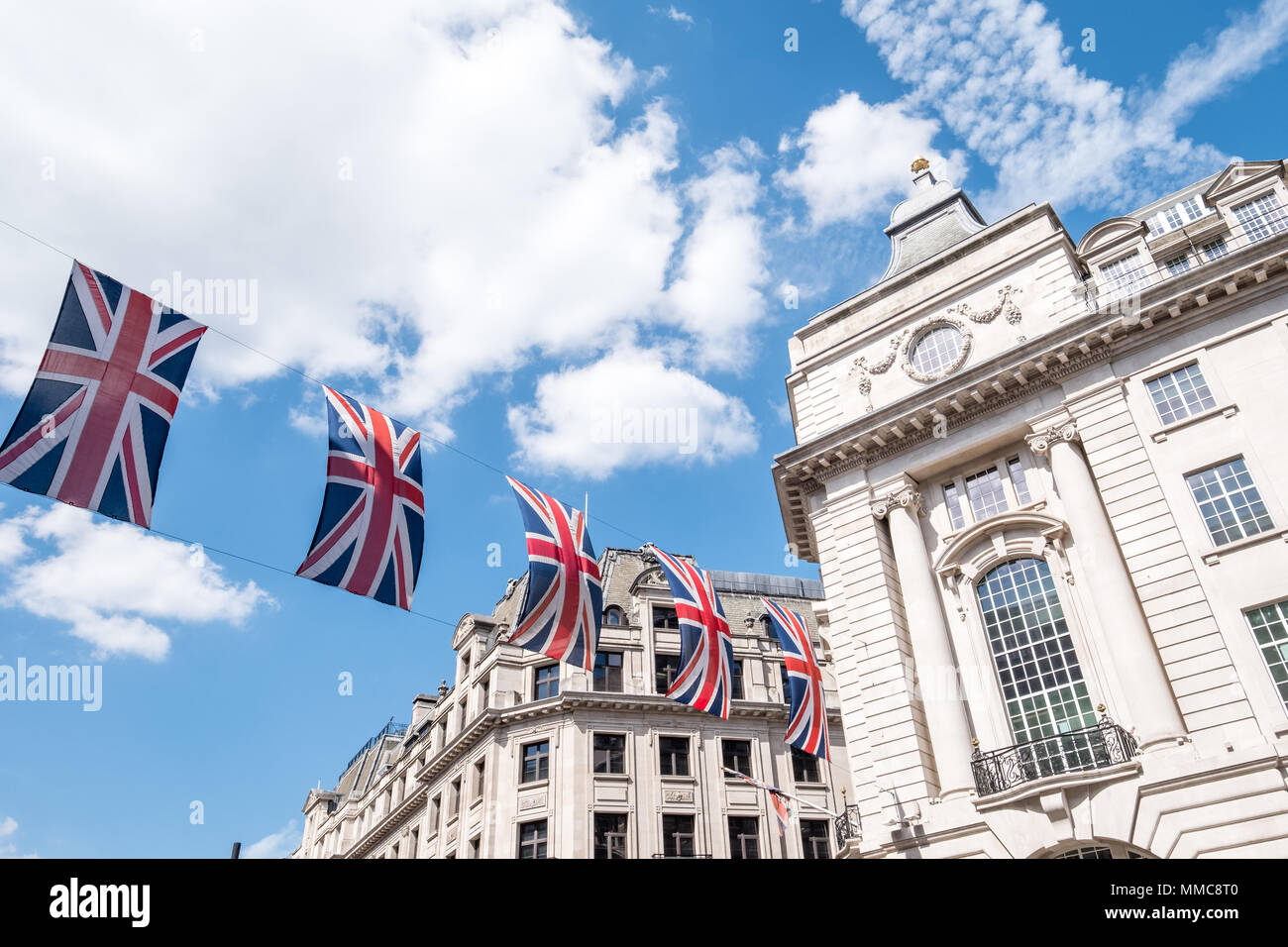 Close up of buildings on Regent Street London with row of British flags ...