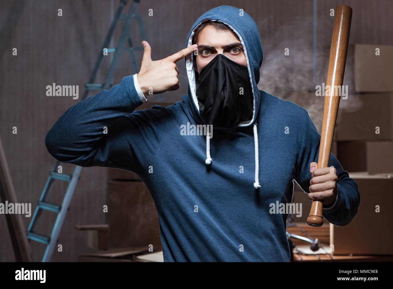 Hooligan with bat in dark room Stock Photo - Alamy