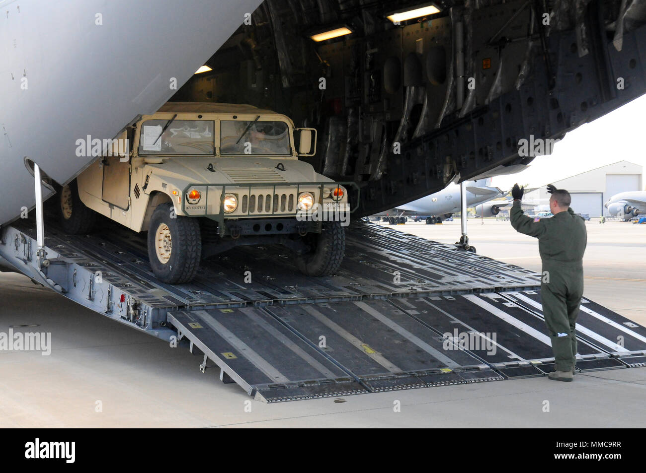 An Airman guides an Ohio Army National Guard Humvee onto a C-17 ...