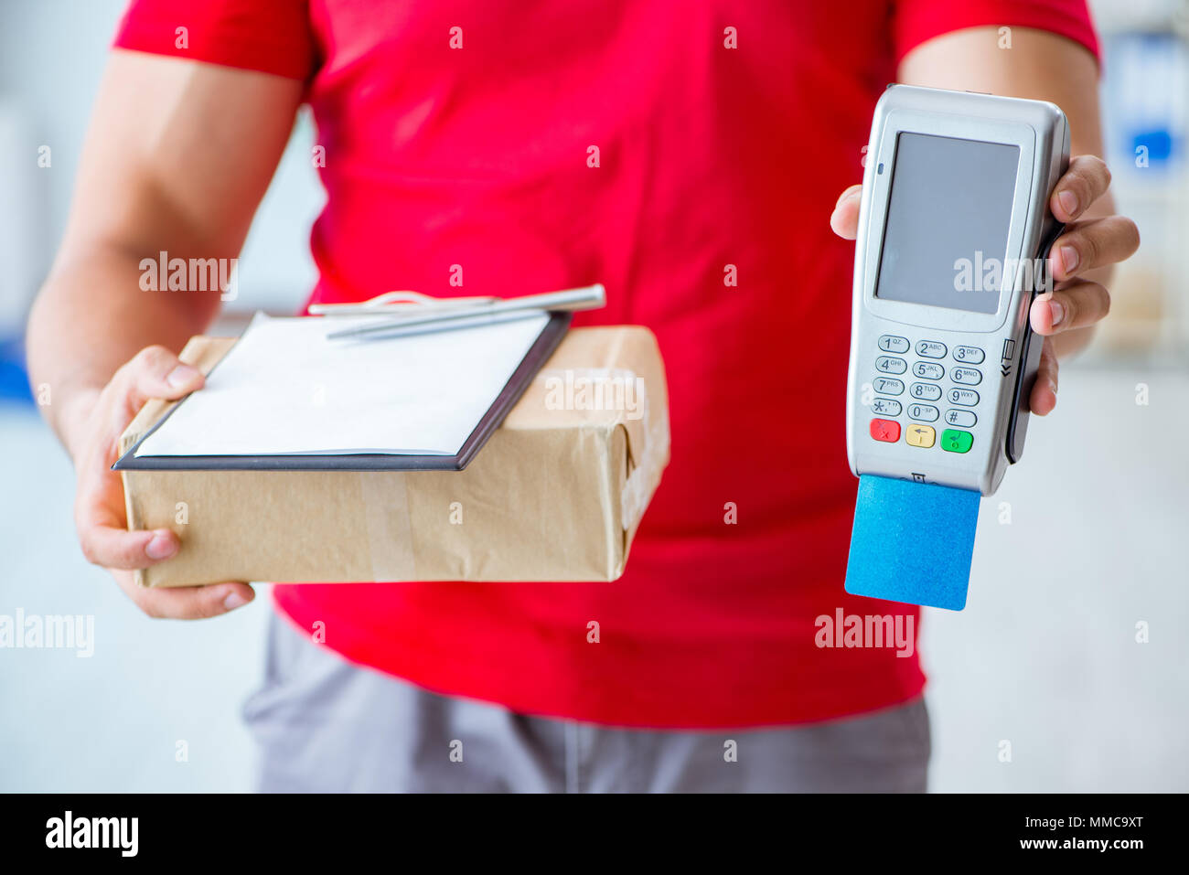 Parcel delivery being paid with pos and credit card Stock Photo - Alamy