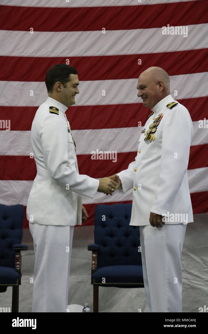 Fleet Survey Team Commanding Officer Cmdr. J.P. Garstka (left) shakes ...