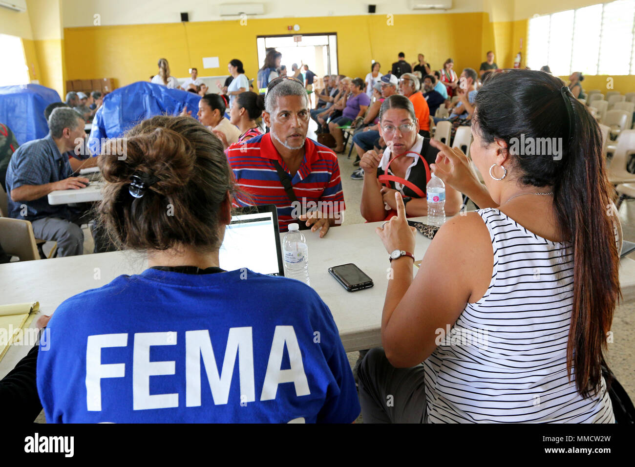 An interpreter uses sign language to help residents, who are hearing ...