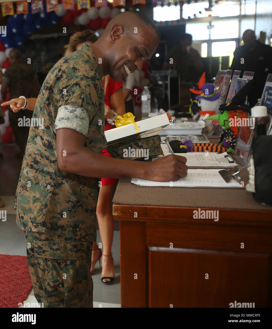 Master Gunnery Sgt. Roosevelt Dunn Jr signs in as the 100,000th patron ...