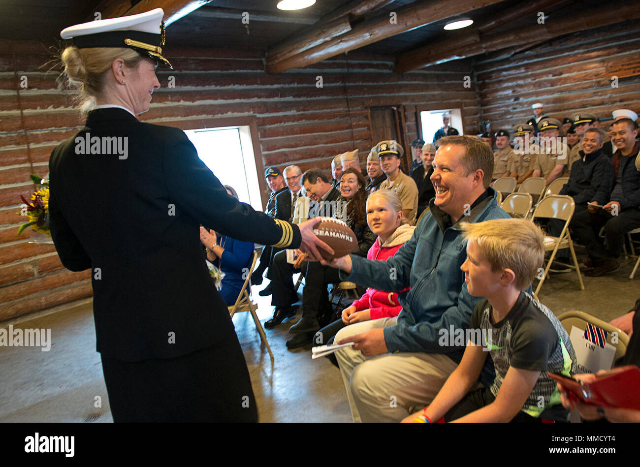 Cmdr. Kerri Chase presents her husband a Seahawks football as a "thank ...