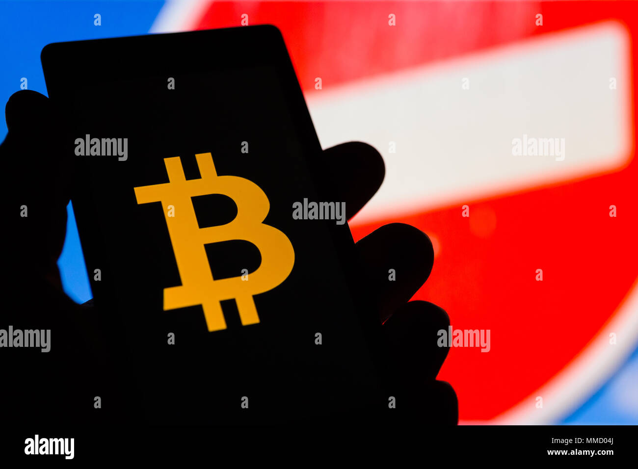 Smartphone in hand with Bitcoin cryptocurrency logo. Prohibiting red ...
