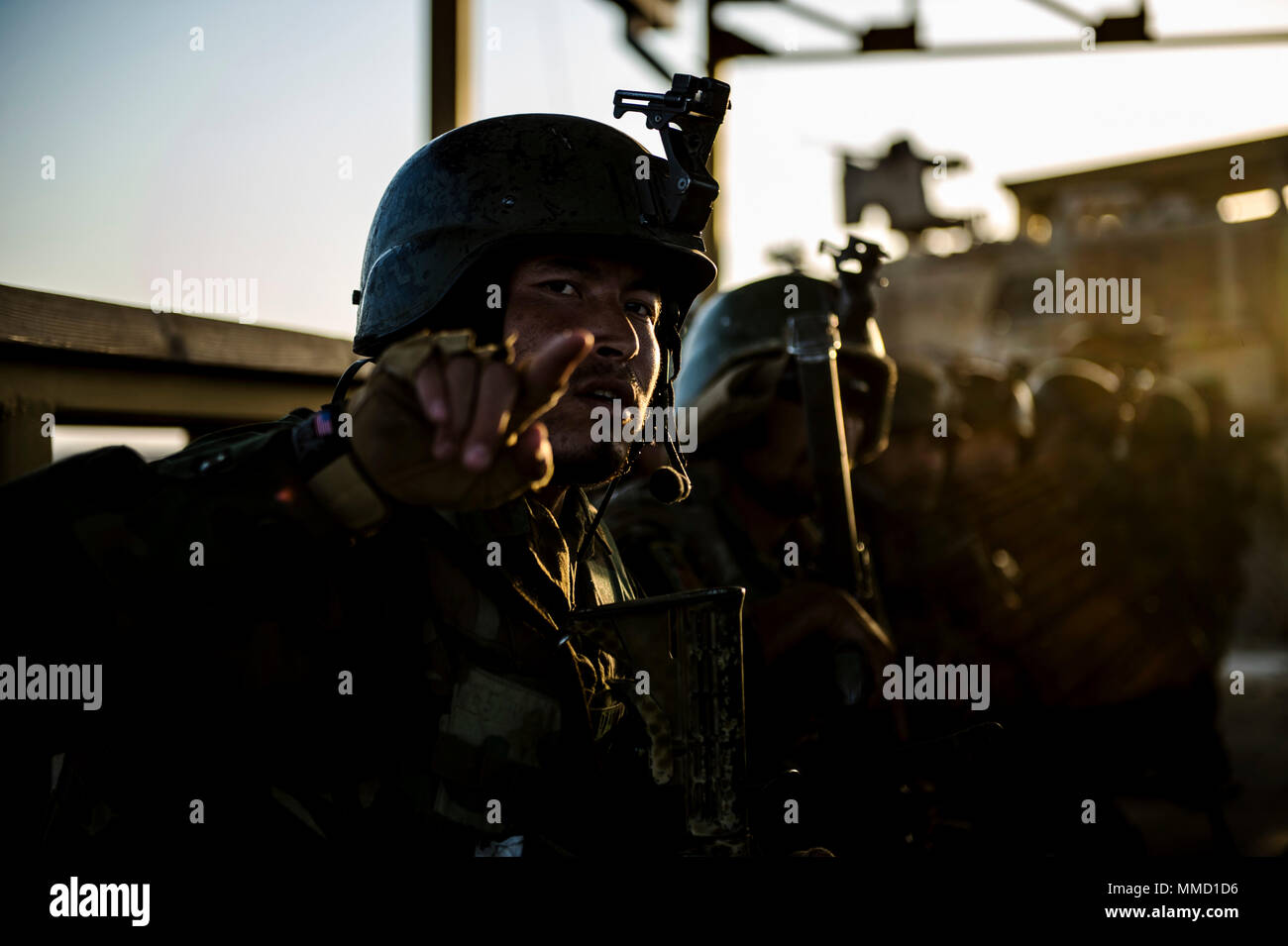 An Afghan Special Security Soldier directs movement of his element ...
