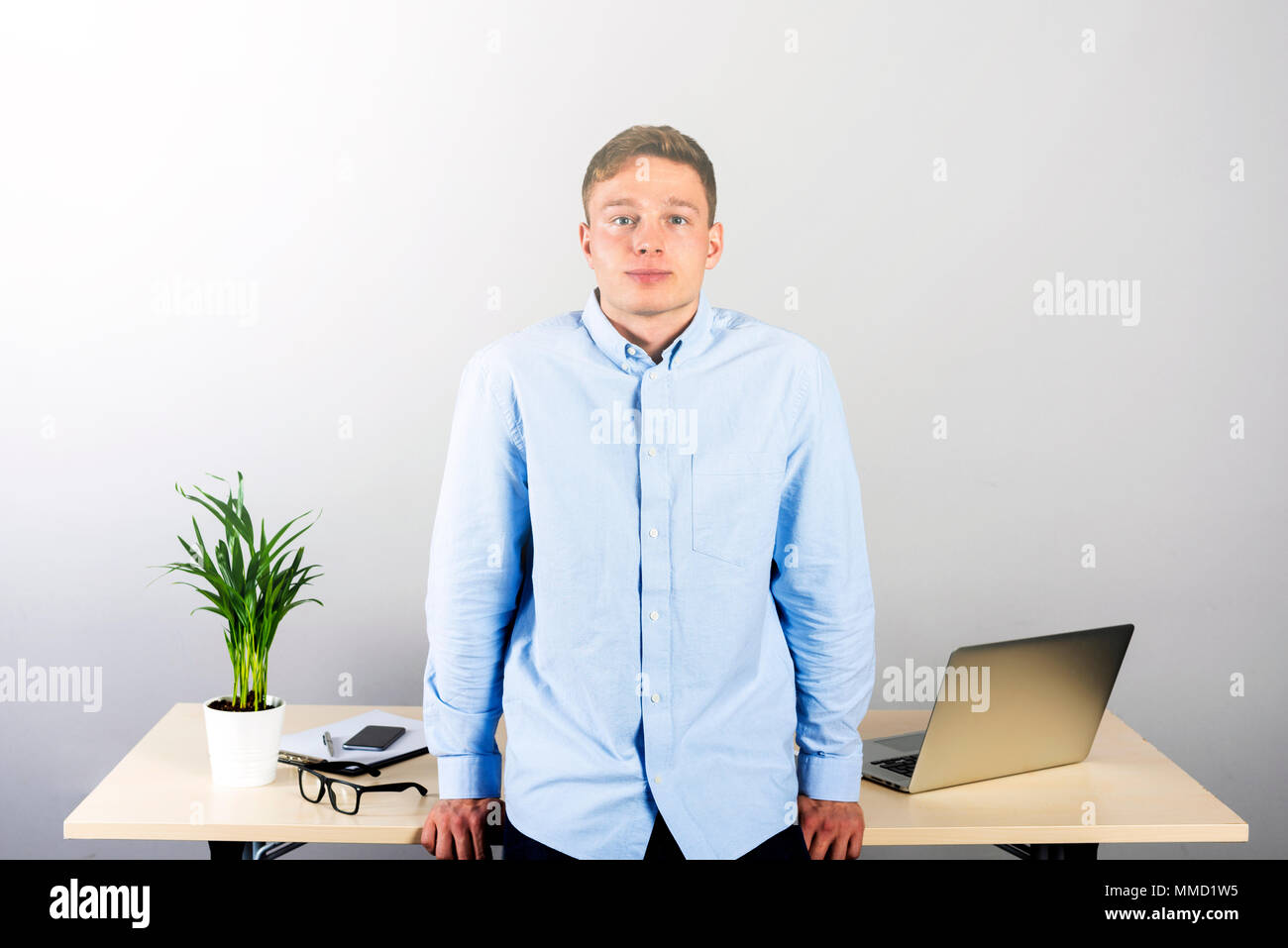 Office man standing by desk smilling Stock Photo - Alamy