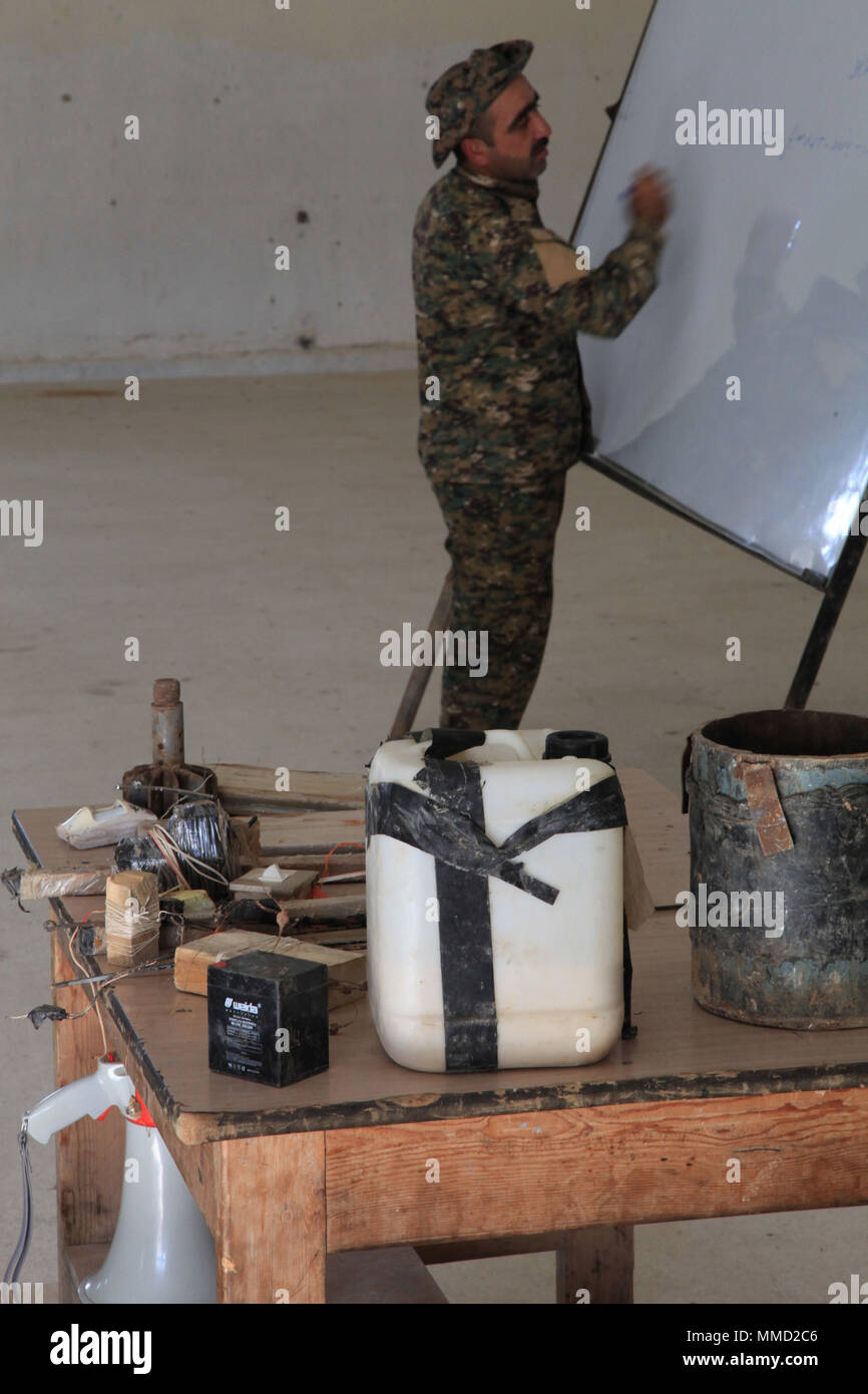 A veteran Syrian Democratic Forces soldier teaches a group of recruits ...