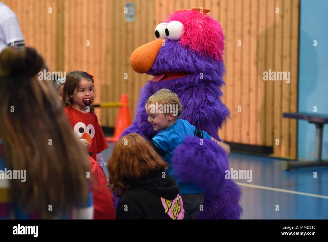 A Sesame Street character hugs a child in the crowd at the USO’s Sesame ...