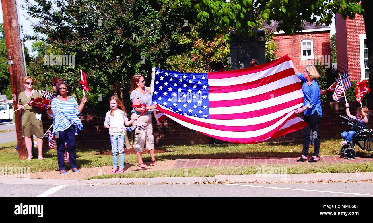 Townspeople in Saluda, Va., line a road cheering and displaying ...