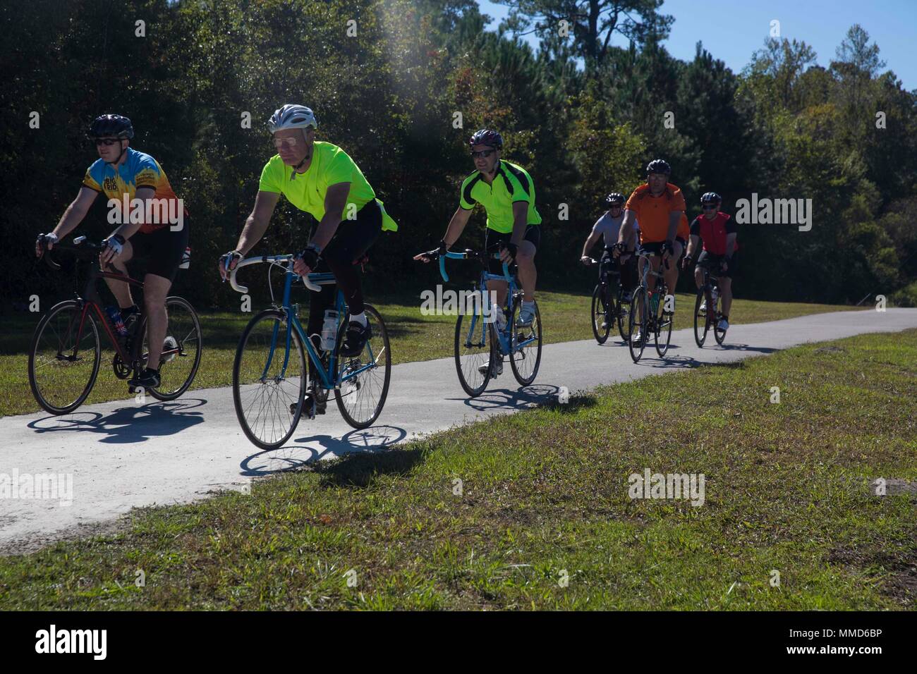 Marines and Sailors ride down trail during a unit bike ride at Camp ...