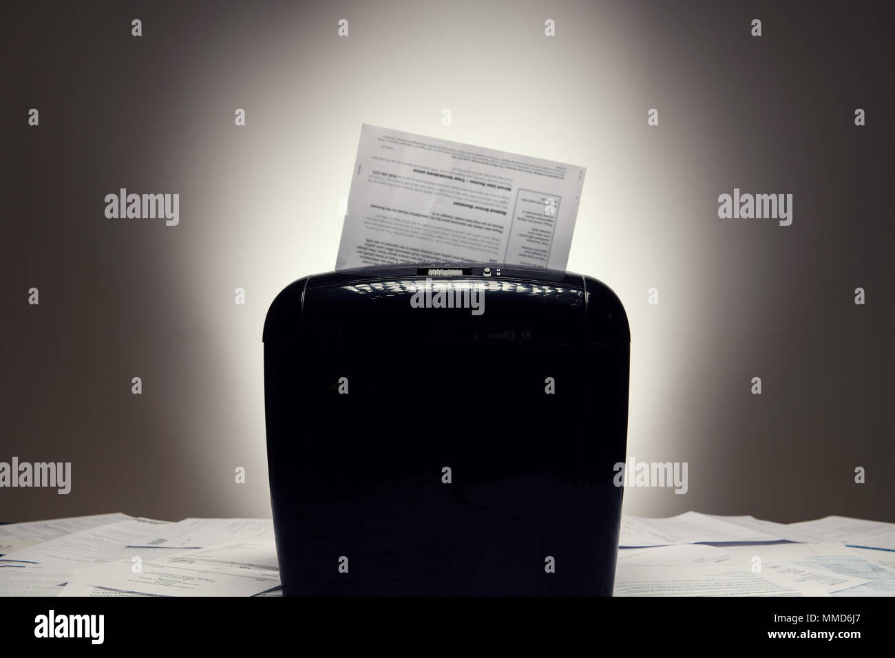 Office shredder on pile of paperwork with personal documents being ...