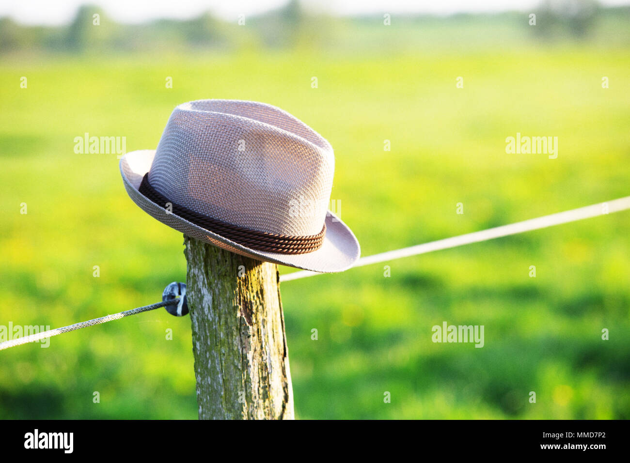 hat on top of a fence post in the fields Stock Photo - Alamy