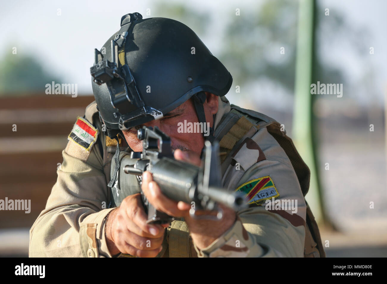 An Iraqi security forces member looks down the sights of an M16 rifle ...