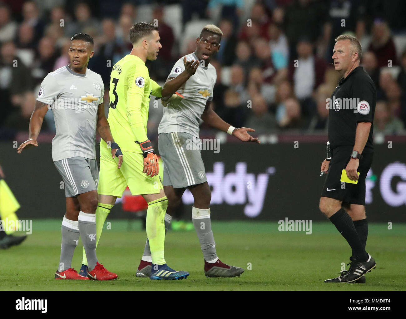 Manchester United's Paul Pogba is guided away by West Ham United ...