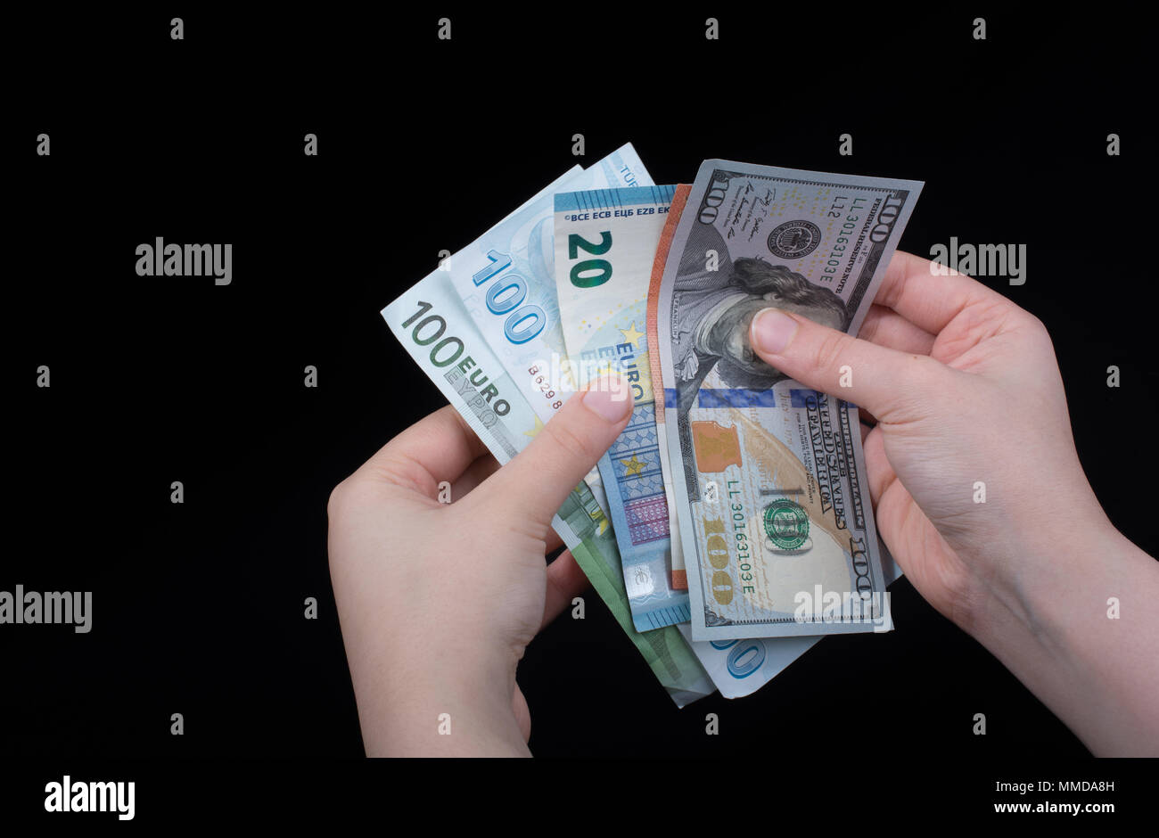 Hand holding American dollar banknotes isolated on black background ...