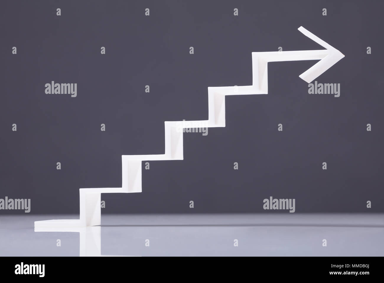 White Increasing Staircase Arrow On Grey Backdrop Stock Photo - Alamy