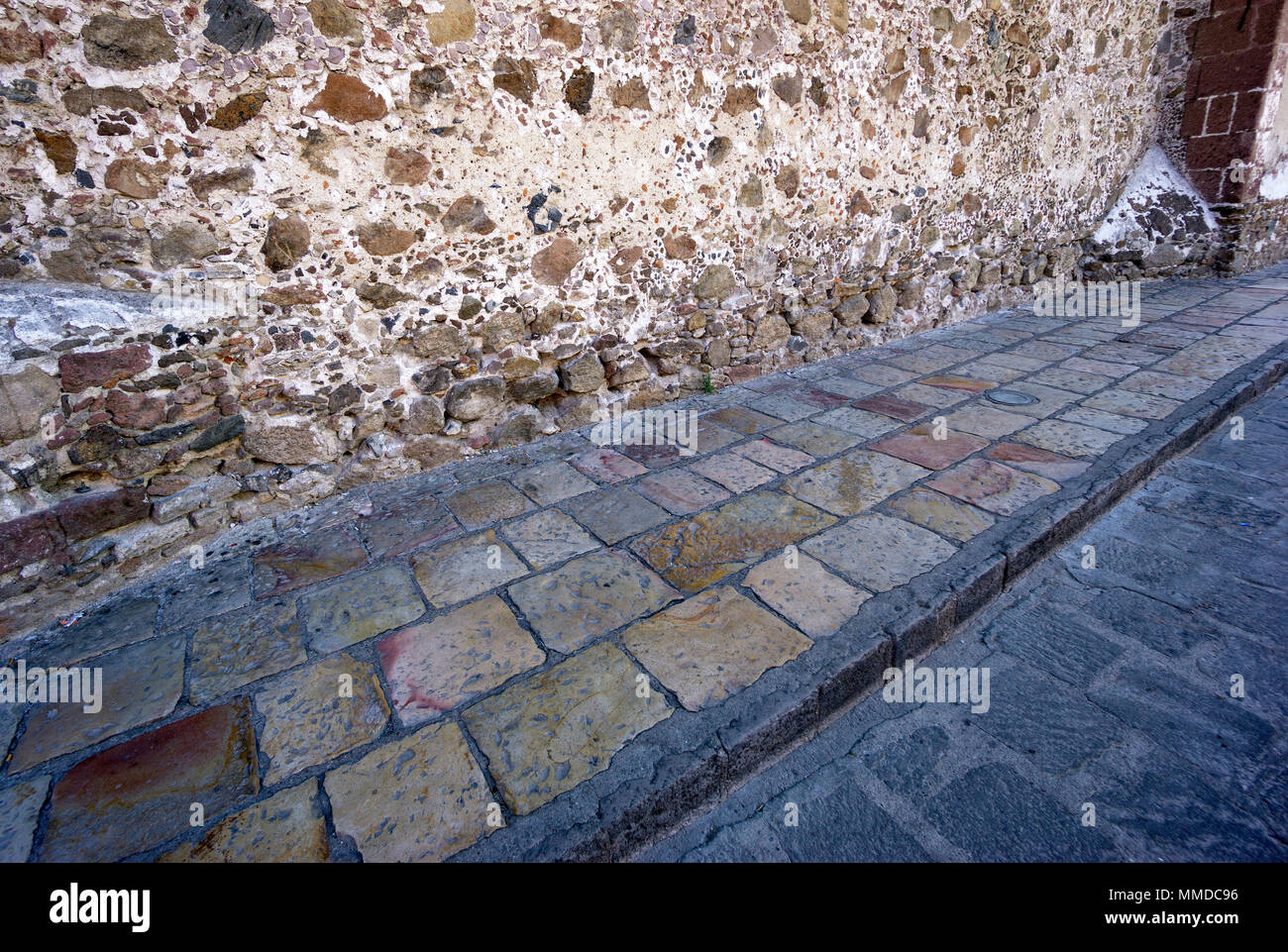 A mix of different types of stones on the sidewalk, street and building ...