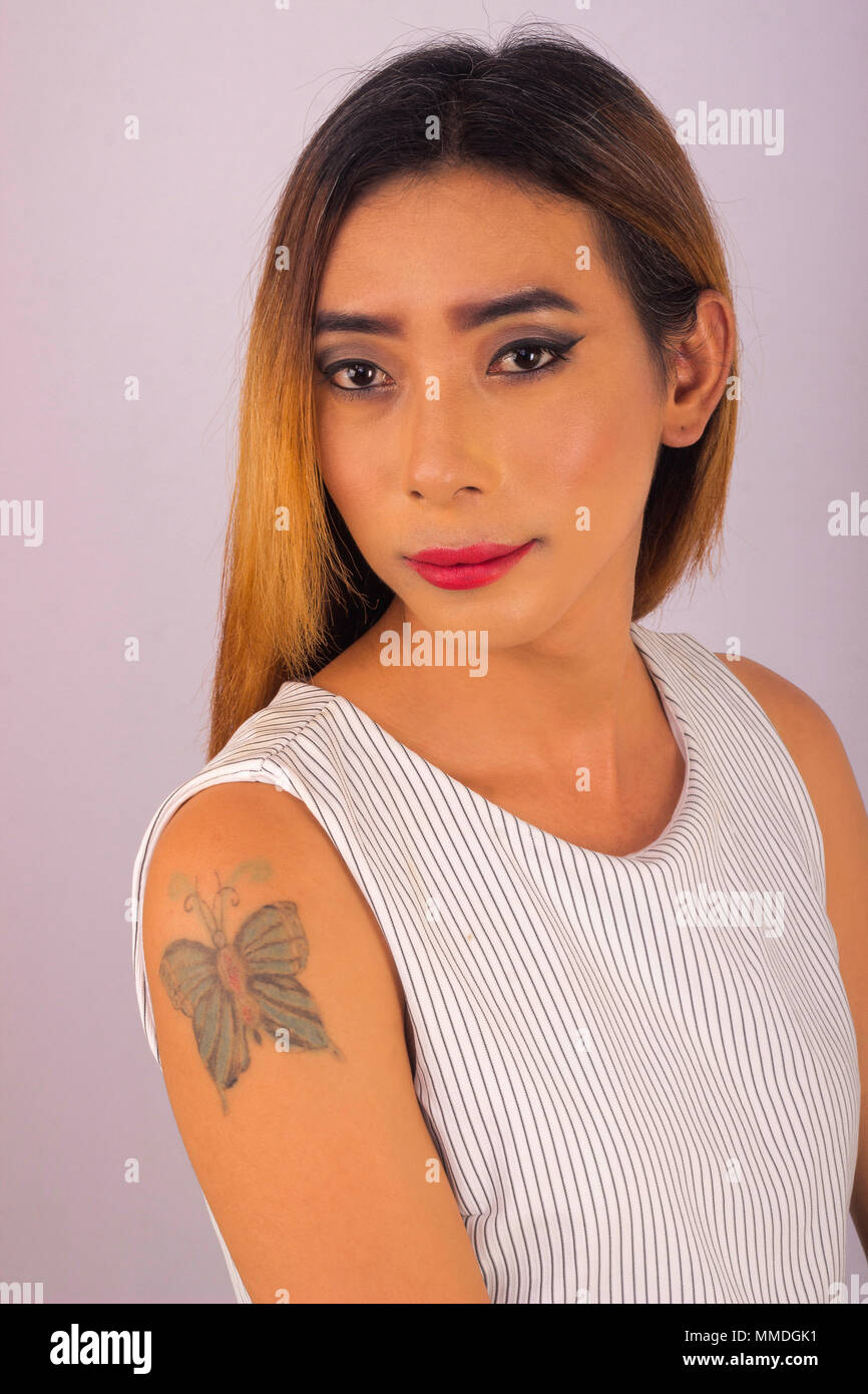 Side pose close-up of woman in white dress and arm tattoo looking at ...