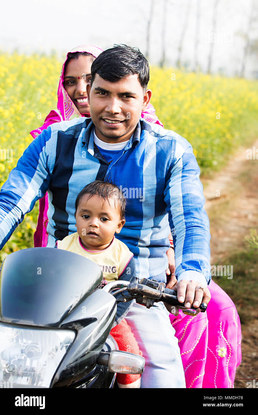 Farmer And Mother with his Son riding a motorcycle in farm Village ...