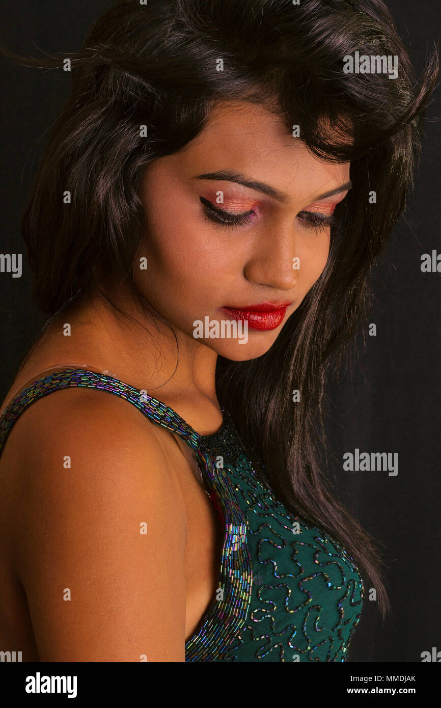 Stylish Indian woman in green dress looking down. Front pose Stock ...