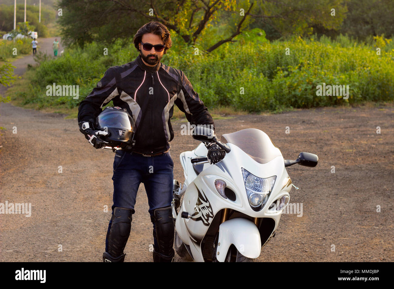 Young man in black attire with a white powerful motorcycle Stock Photo ...