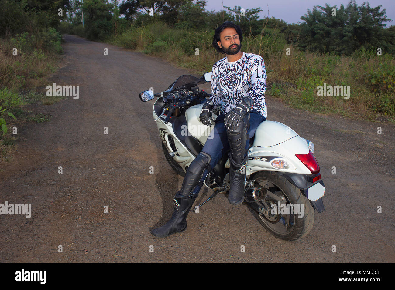 Young man in white attire with a white powerful motorcycle Stock Photo ...