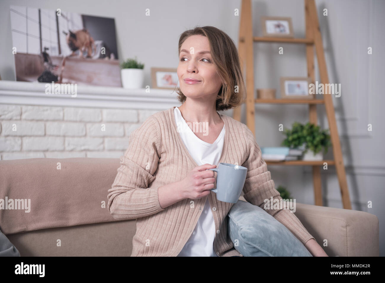 Alert woman sitting on the couch Stock Photo - Alamy