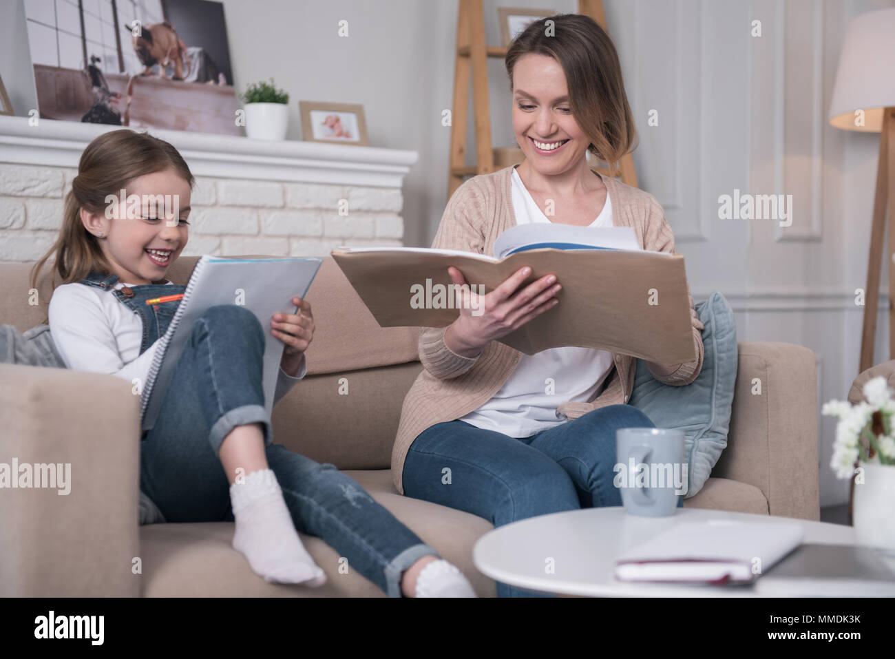 Smiling mummy and daughter studying together Stock Photo - Alamy