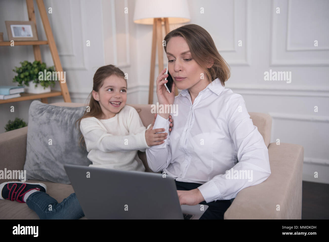 Concentrated mother talking on the phone Stock Photo - Alamy