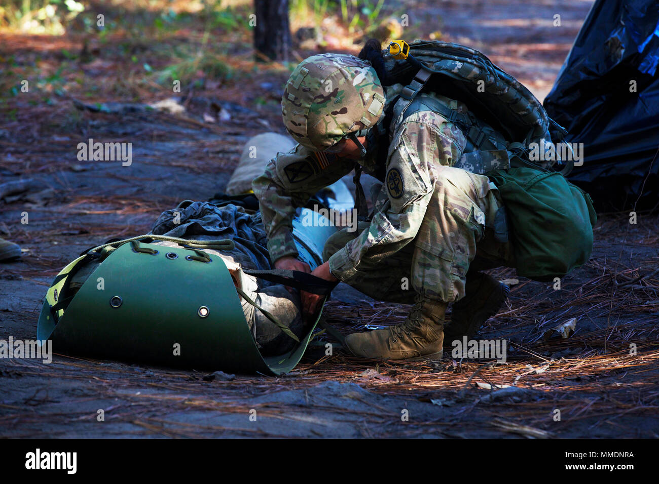 U.S. Army soldier secures a patient during the Expert Field Medical ...