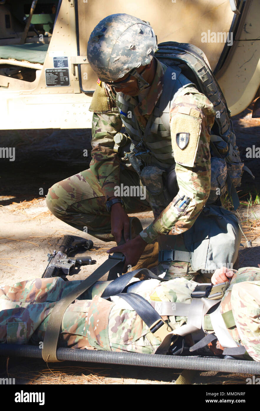 U.S. Army soldiers uses his belt to secure a patient during the Expert ...