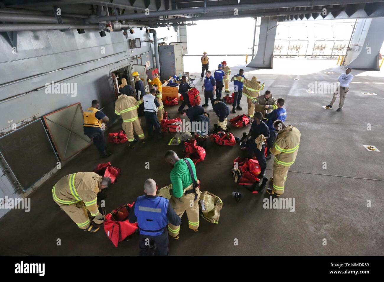 Sailors don protective gear during a fire evacuation drill aboard USS ...