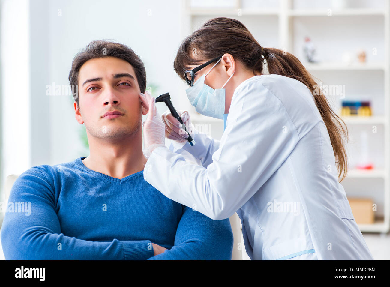 Doctor checking patients ear during medical examination Stock Photo - Alamy