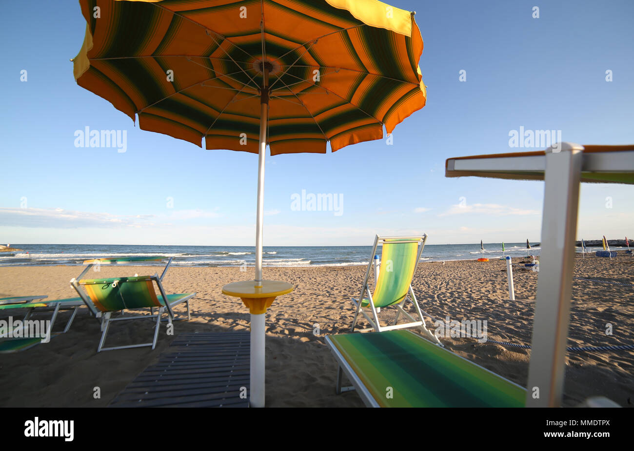 yellow beach umbrella open at the beach without anyone with two ...