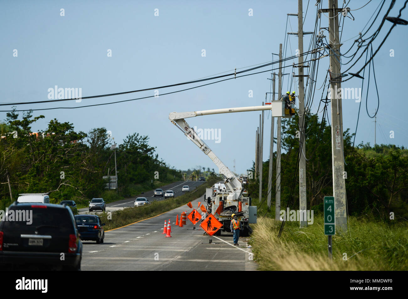 Puerto Rican electric company workers restore power lines along Highway ...