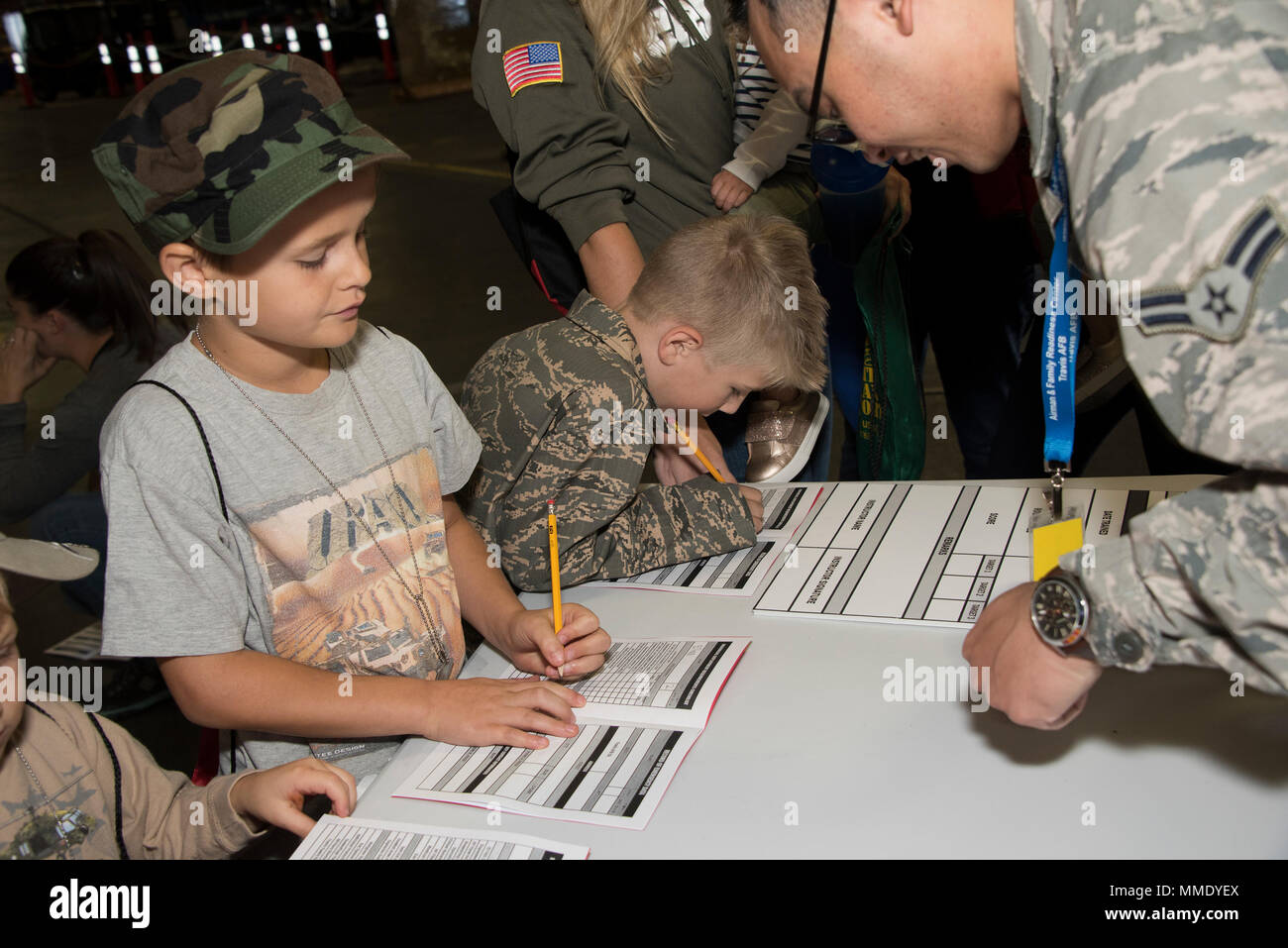 Two young boys fill out forms as part of their “out-processing” at the ...