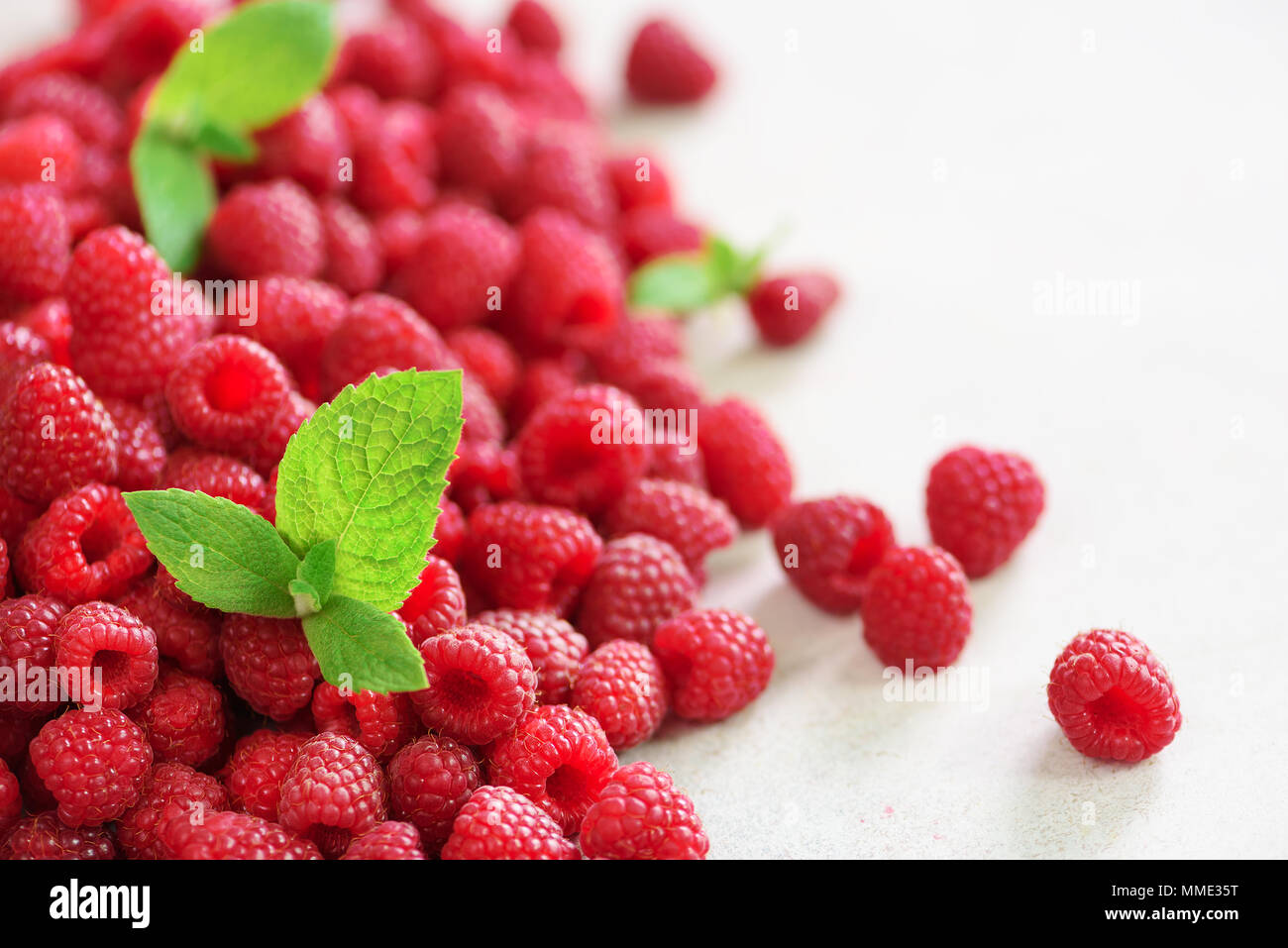 Fresh organic raspberries with mint leaves. Fruit background with copy ...